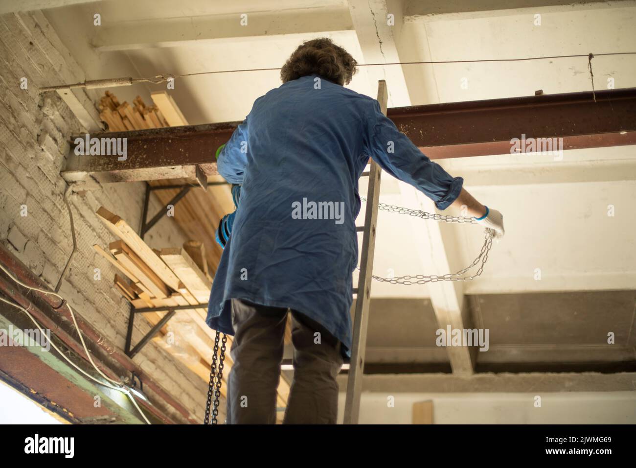 worker hangs chain on steel beam. Construction staircase Stock Photo ...