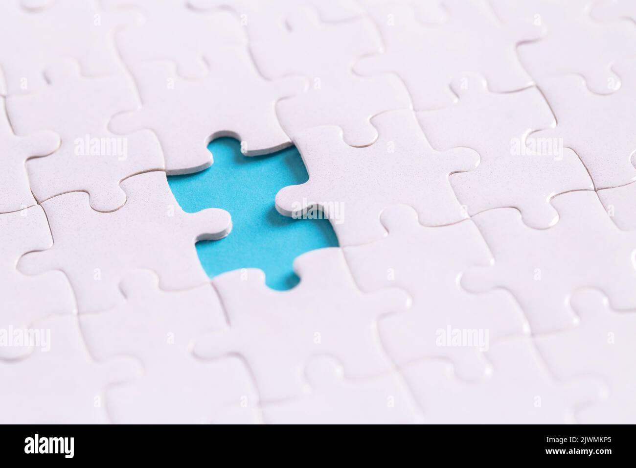 Unfinished jigsaw puzzle on blue background with copy space for your ...