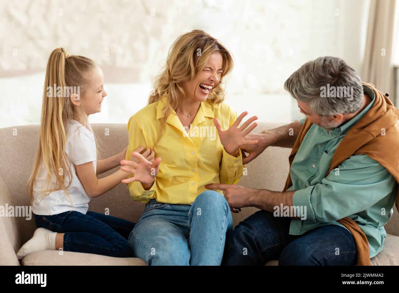 Father And Little Daughter Tickling Happy Mother Laughing At Home Stock ...