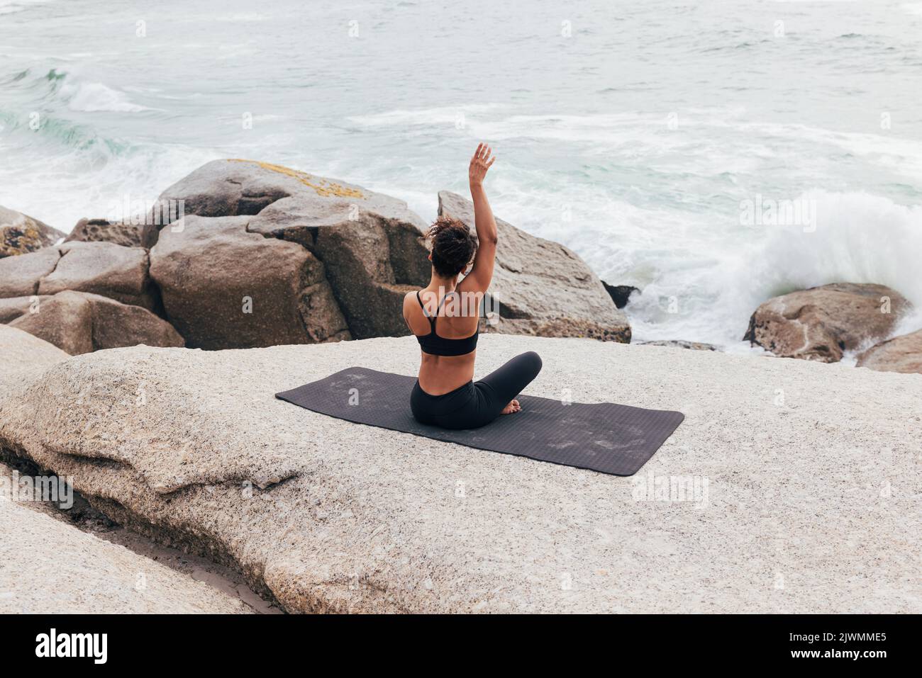 Rear view of fit female raising hand while changing yoga pose. Woman ...