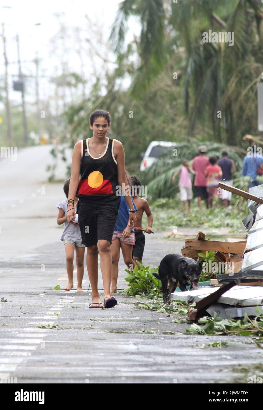 Locals walk the main street of devastated Tully, North Queensland, as a ...