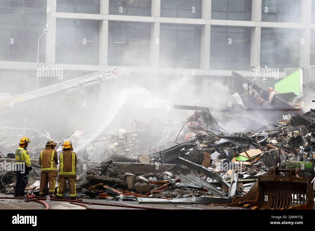 Fire fighters attend to a building that collapsed after a magnitude 6.3 ...