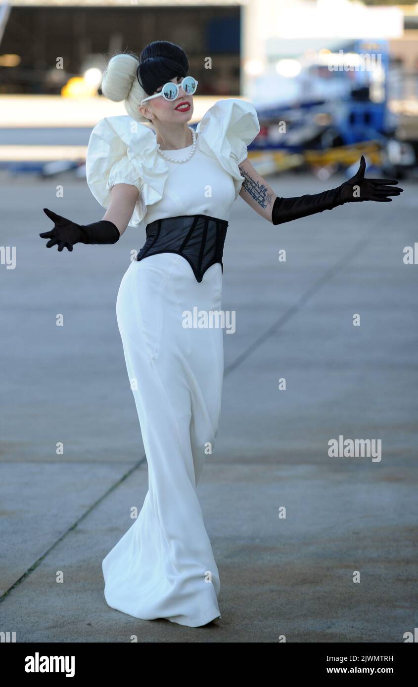 Performer Lady Gaga steps waves as she walks across the tarmac after ...