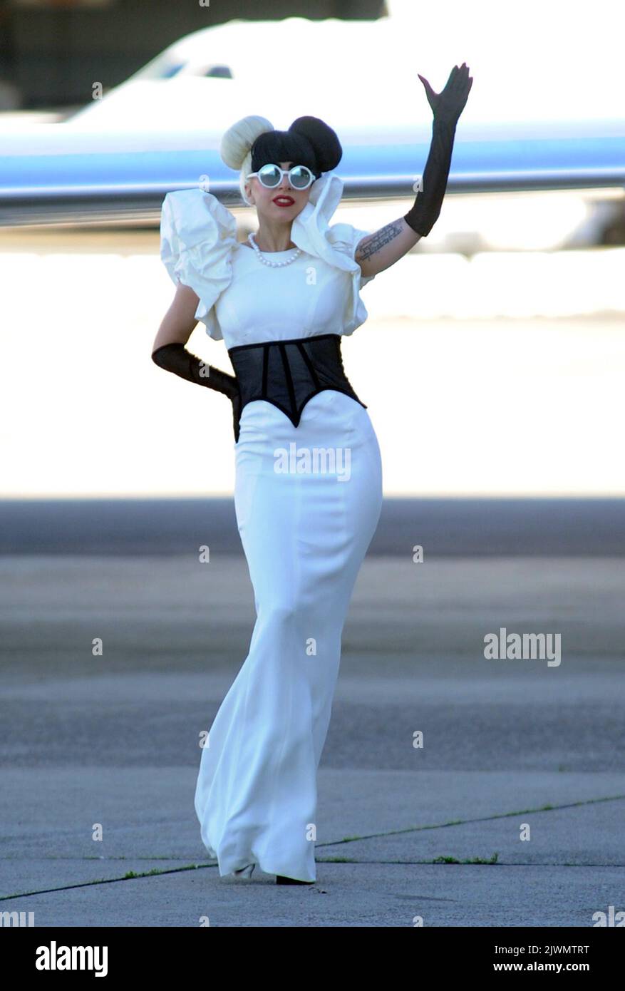 Performer Lady Gaga steps waves as she walks across the tarmac after ...