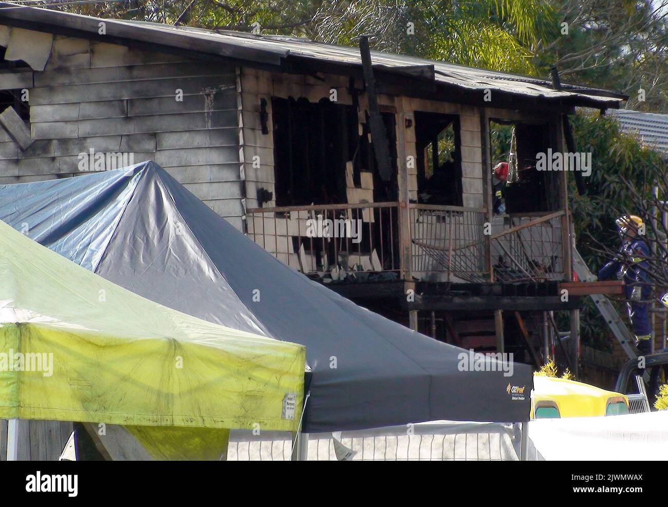 Qld Fire and Rescue officers work to shore up the house ** STRICTLY ...
