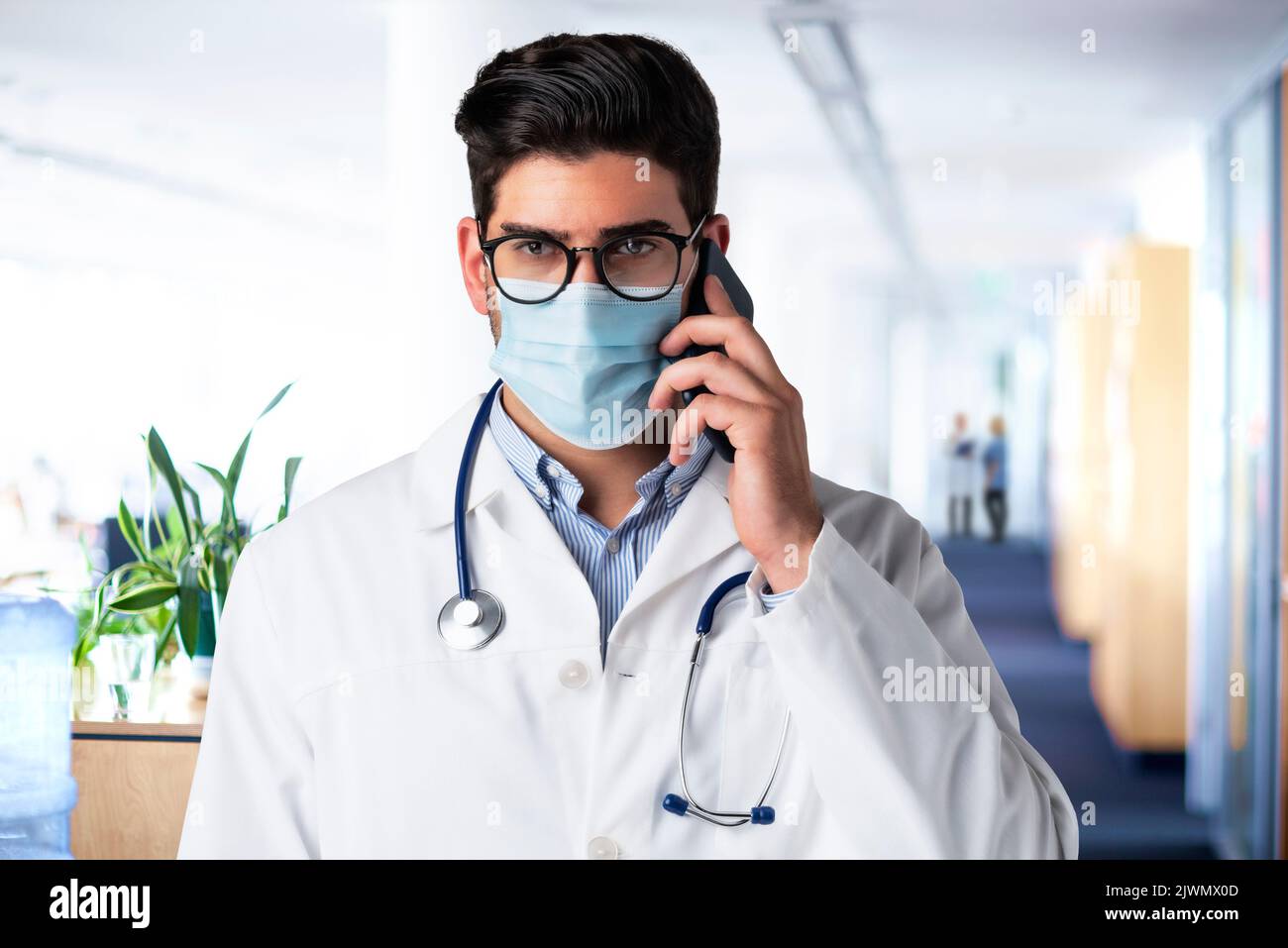 Doctor talking on smartphone hi-res stock photography and images - Alamy