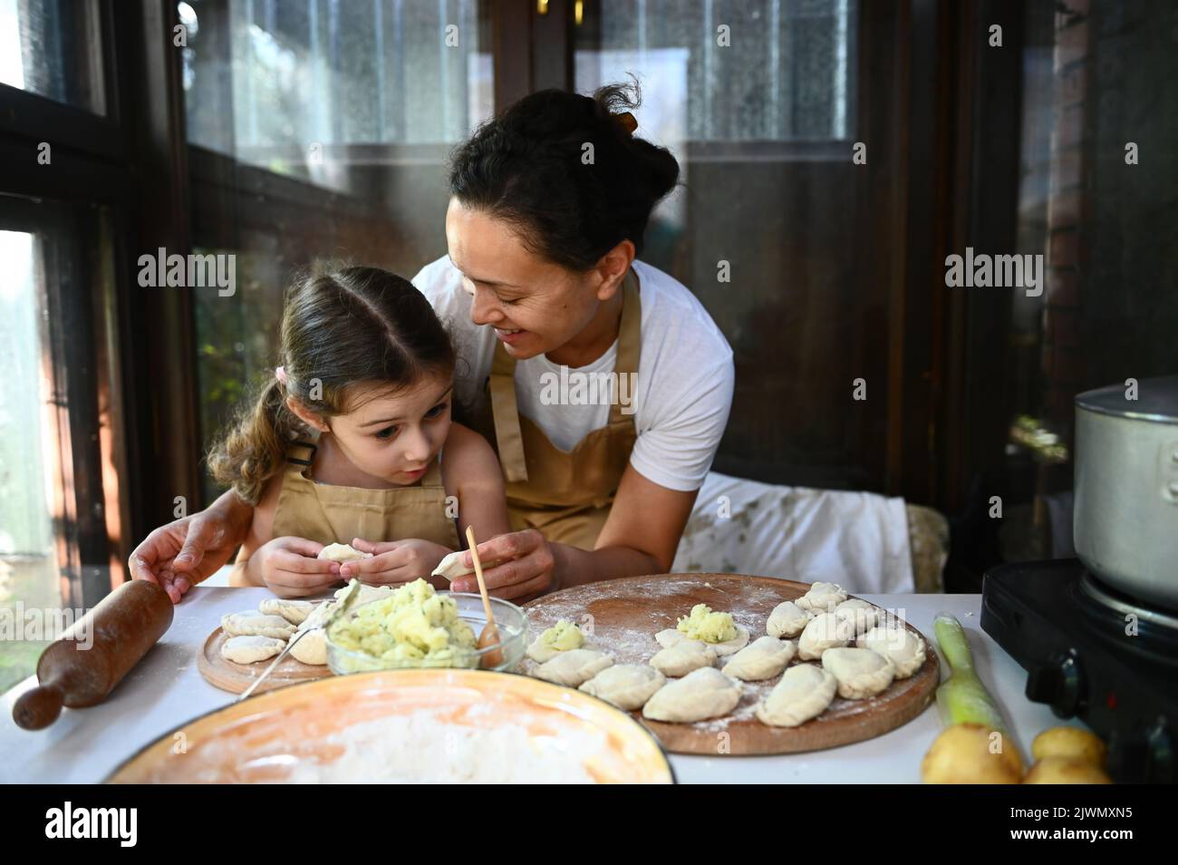 Loving mother hugging her adorable daughter, standing together at a ...
