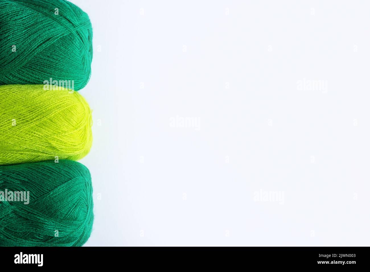 Green yarn threads on a white background for knitting. Flat lay Stock ...