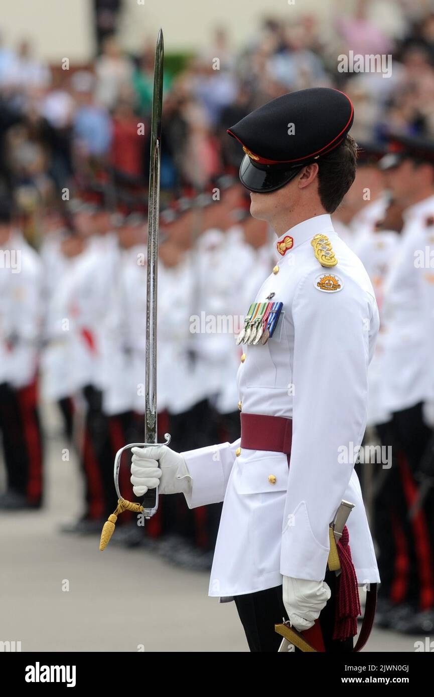 An officer cadet stands on parade with cap askew before the arrival of ...