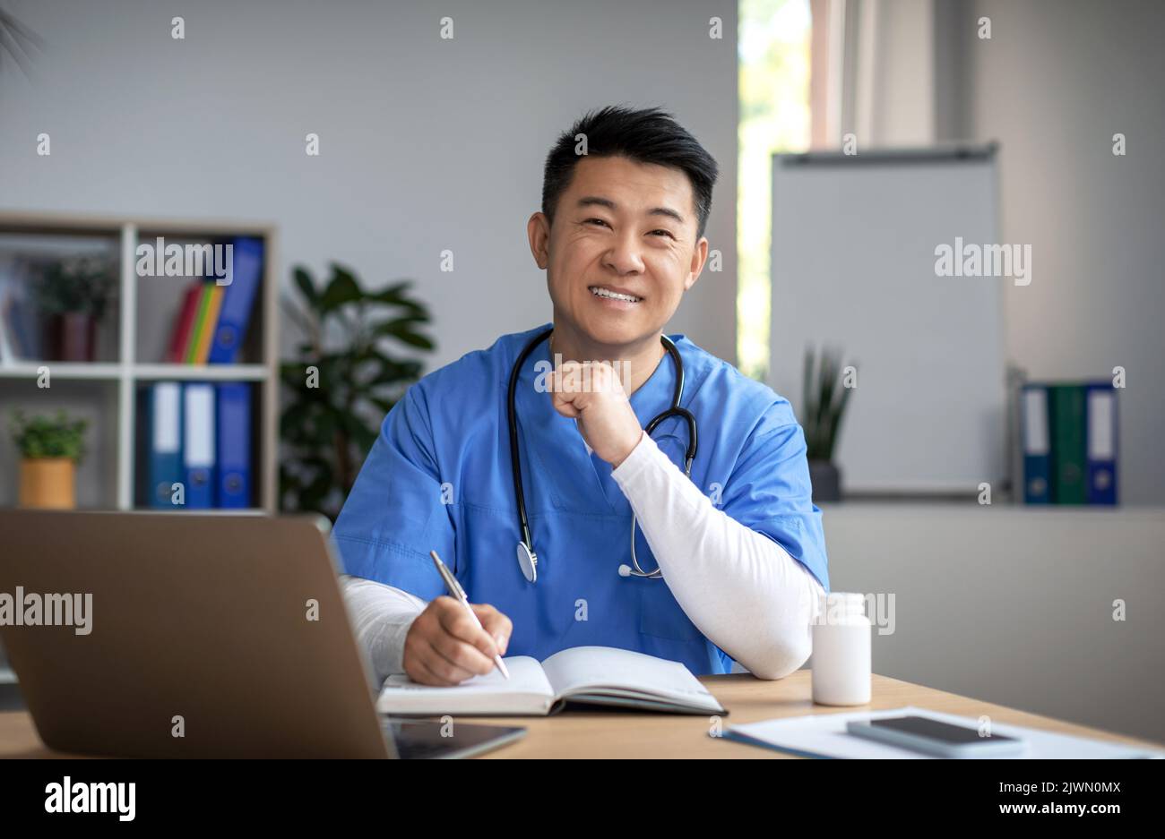 Cheerful young korean male doctor in uniform with stethoscope at ...