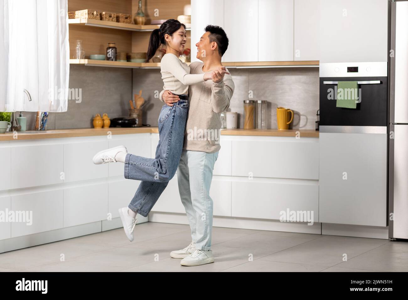 Romantic chinese lovers dancing waltz at kitchen Stock Photo - Alamy