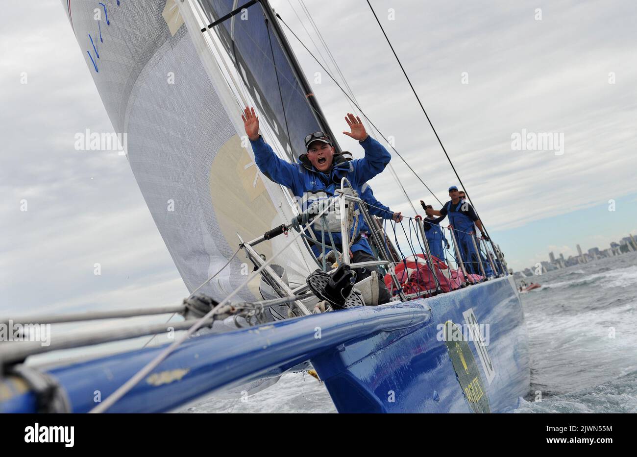 A crewman on the bow of Wild Thing gestures to the media boat A-Team to ...