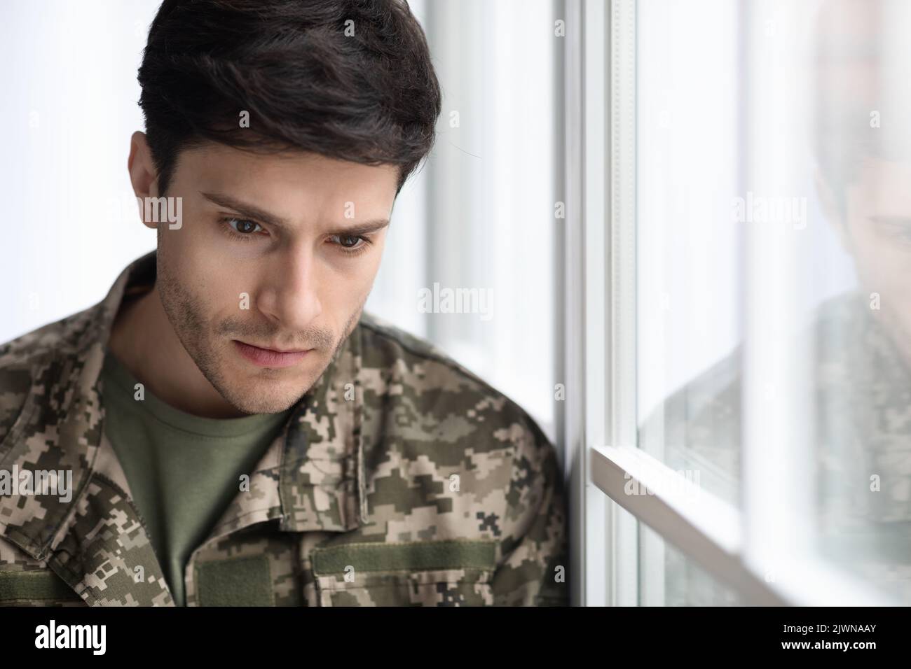 depressed military guy standing next to window, closeup Stock Photo - Alamy