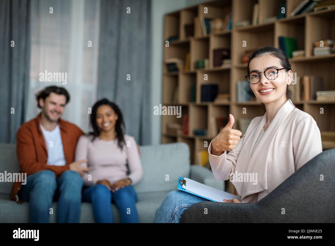 Glad smiling young international family at meeting with psychologist in ...