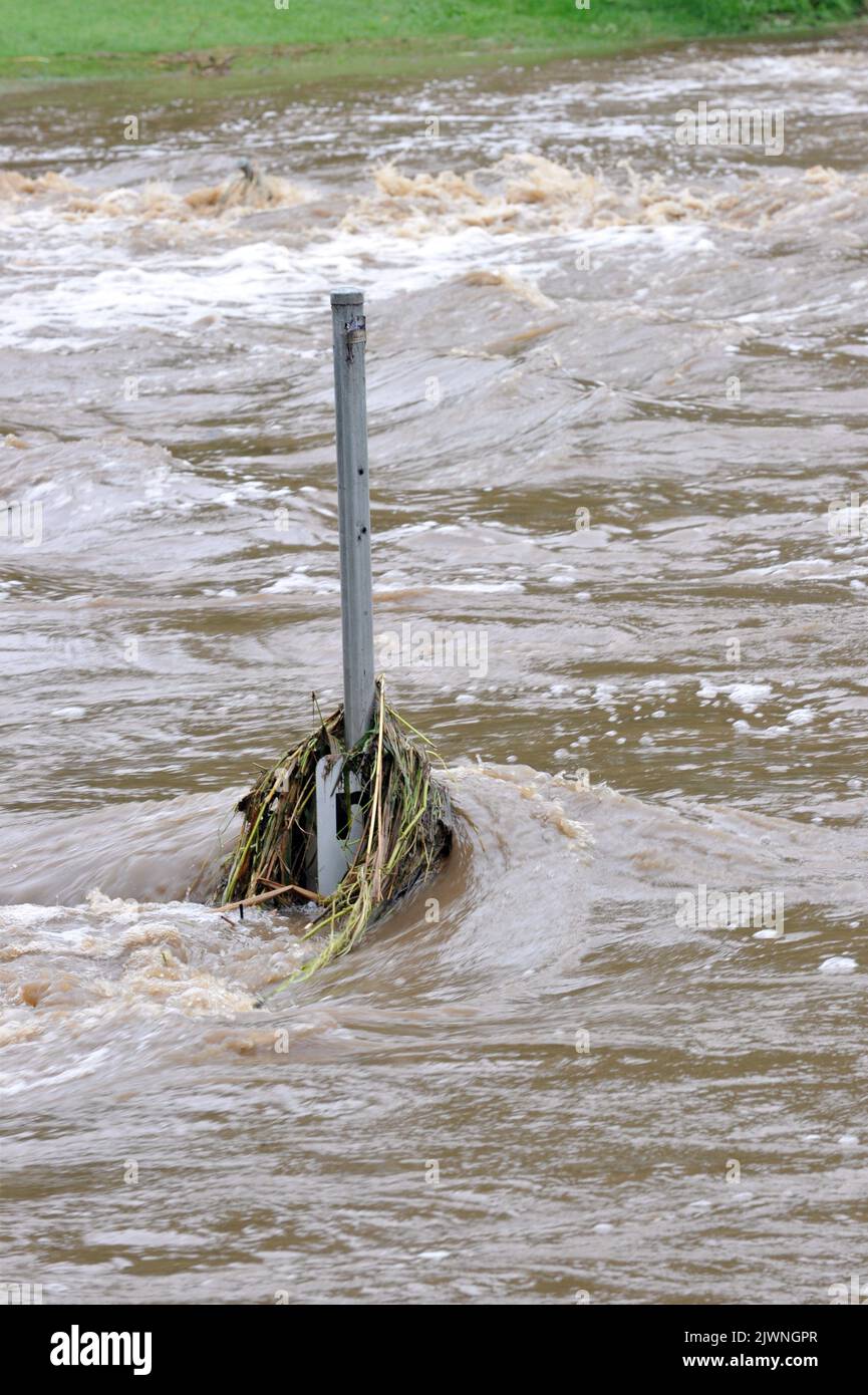 Water rushes past the depth sign of a road crossing at Cooma Creek in ...