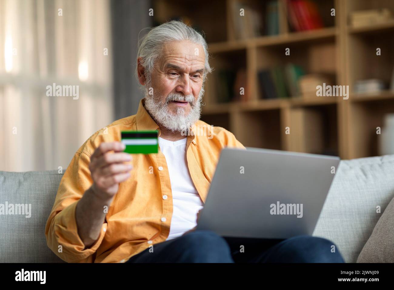 Excited senior man using laptop and credit card at home Stock Photo - Alamy