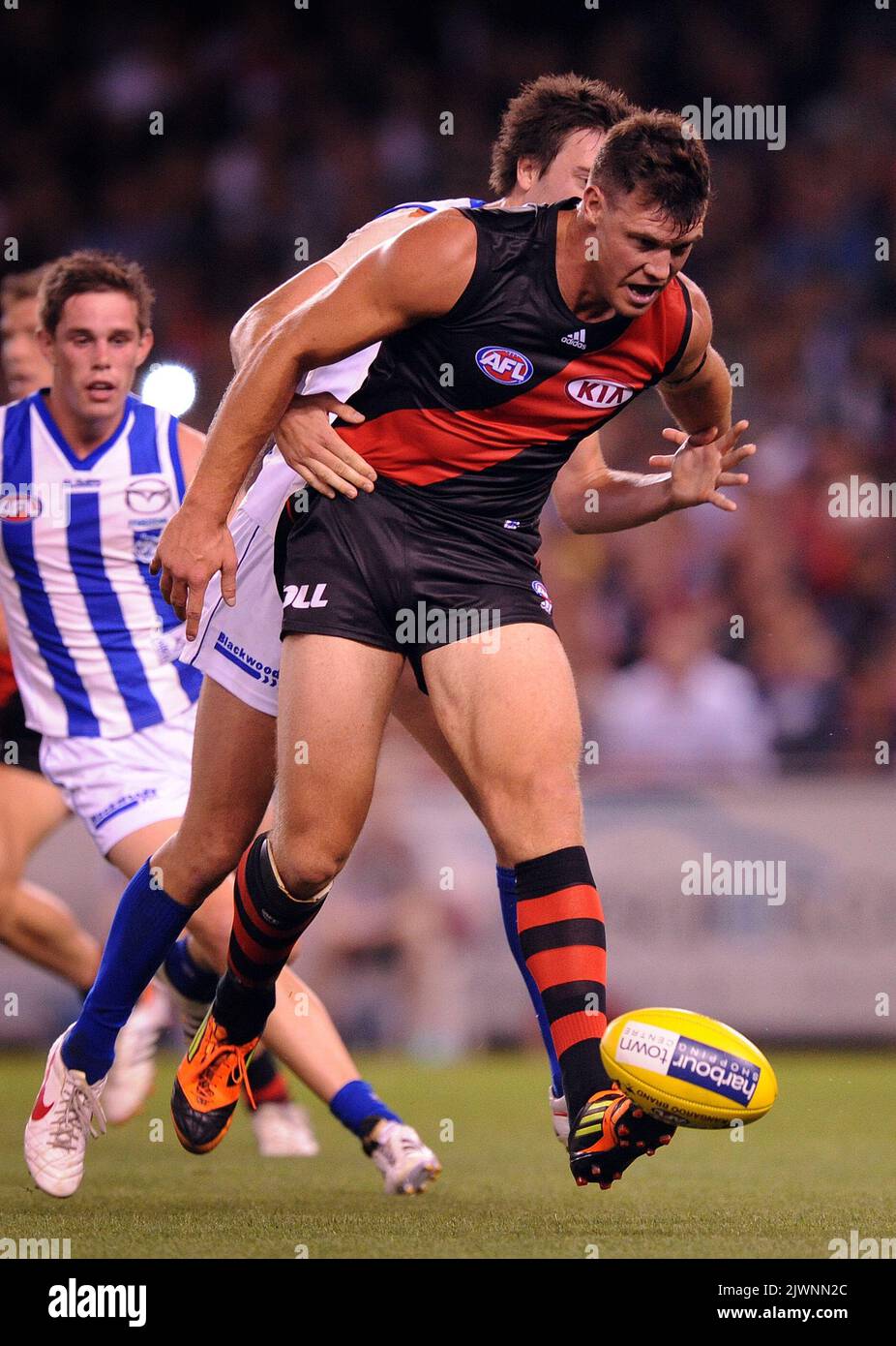 David Hille of Essendon gets a kick away past Samuel Wright of North ...