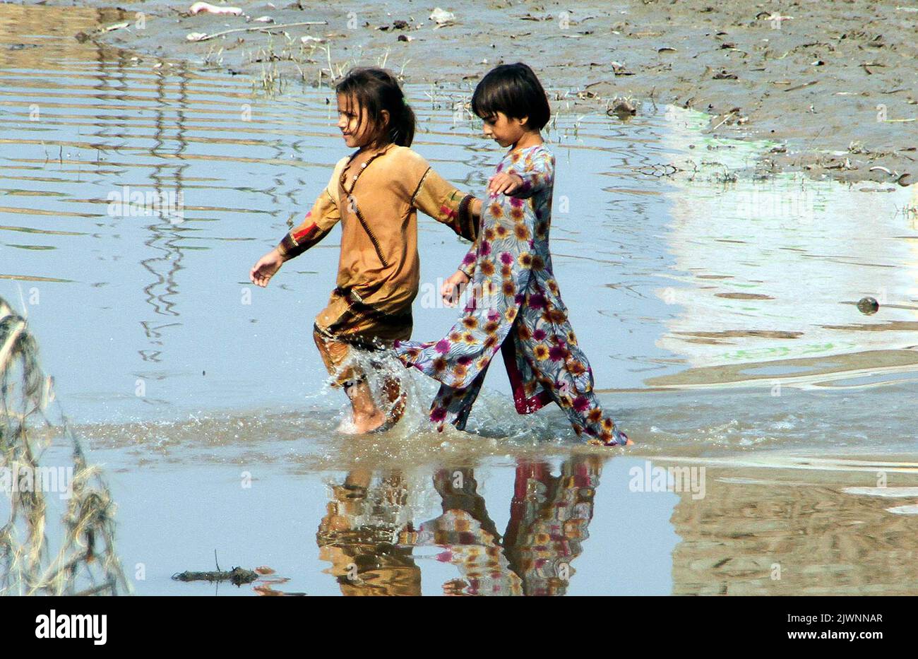 Girls are passing through a flood waters after flood water flowed in ...