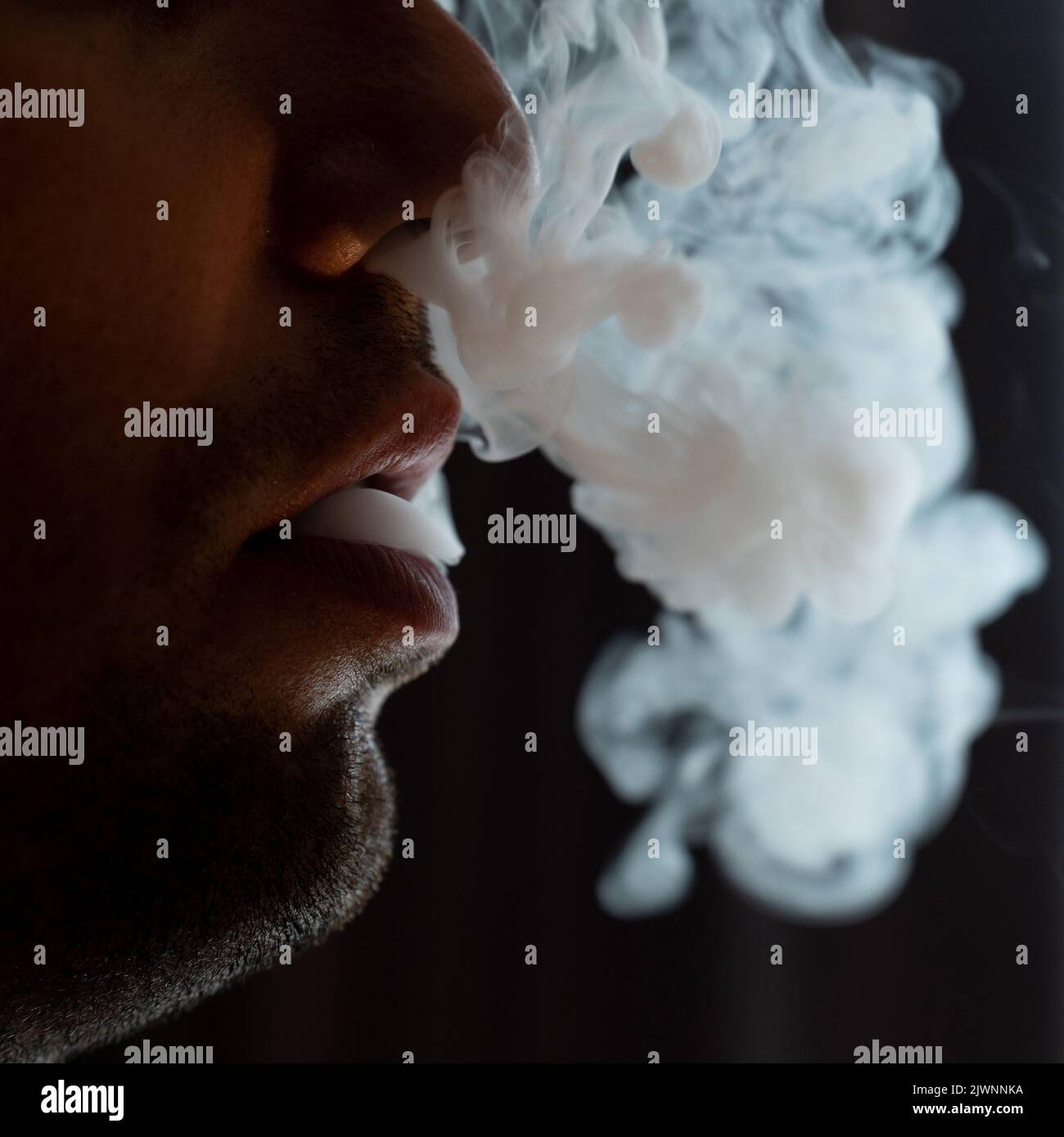 Male lips blowing smoke close-up, cigarette smoke and lips on black ...