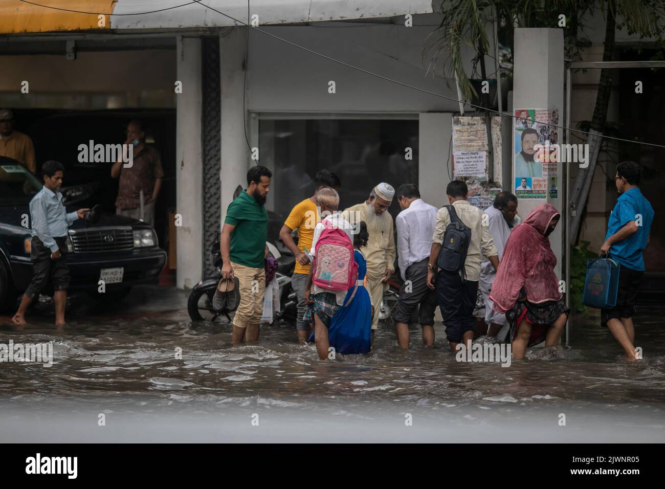 People walk on a waterlogged streets after a heavy monsoon rain in ...