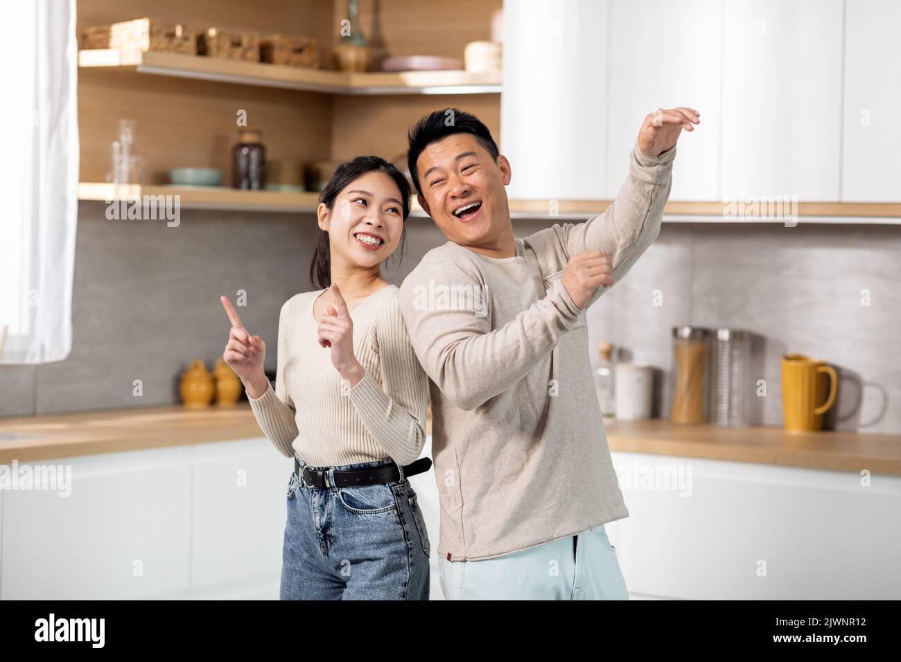 Crazy japanese couple having fun together at kitchen Stock Photo - Alamy