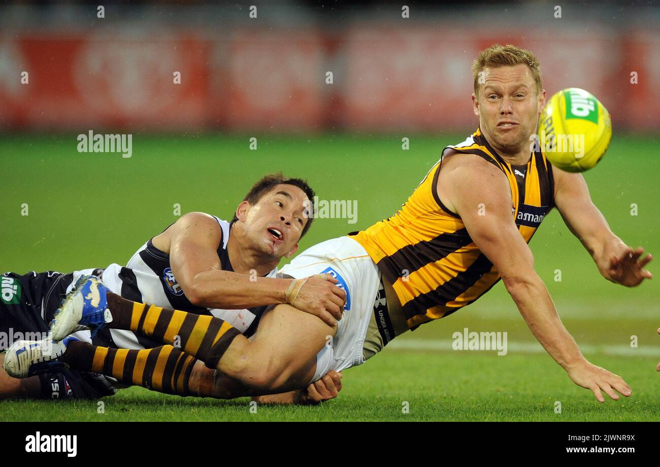 Sam Mitchell of Hawthorn is tackled by Mathew Stokes of Geelong, during ...