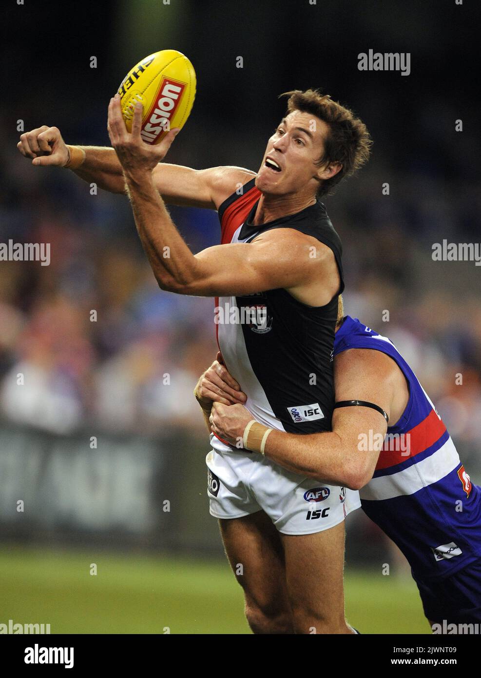 Adam Cooney of the Western Bulldogs tackles Lenny Hayes of St Kilda, in ...