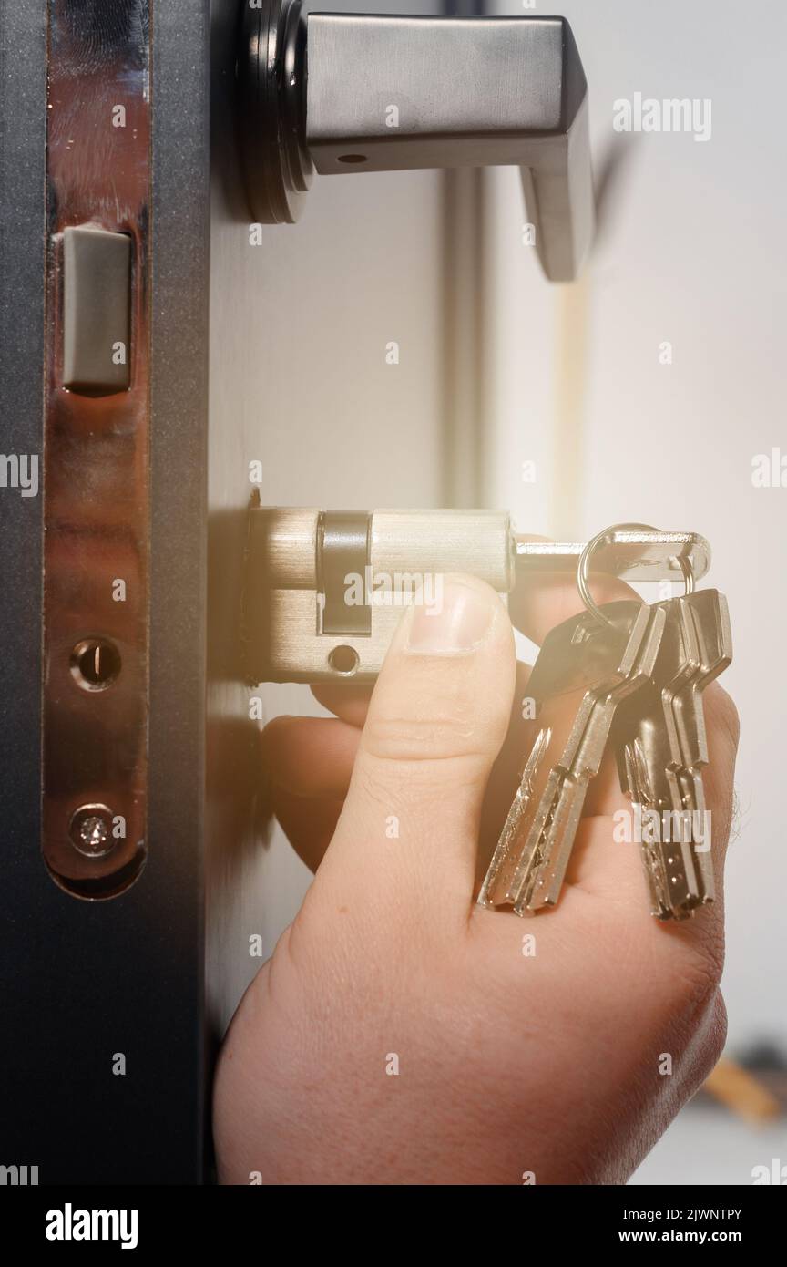 The master installs the core for the door lock, assembly work with the ...