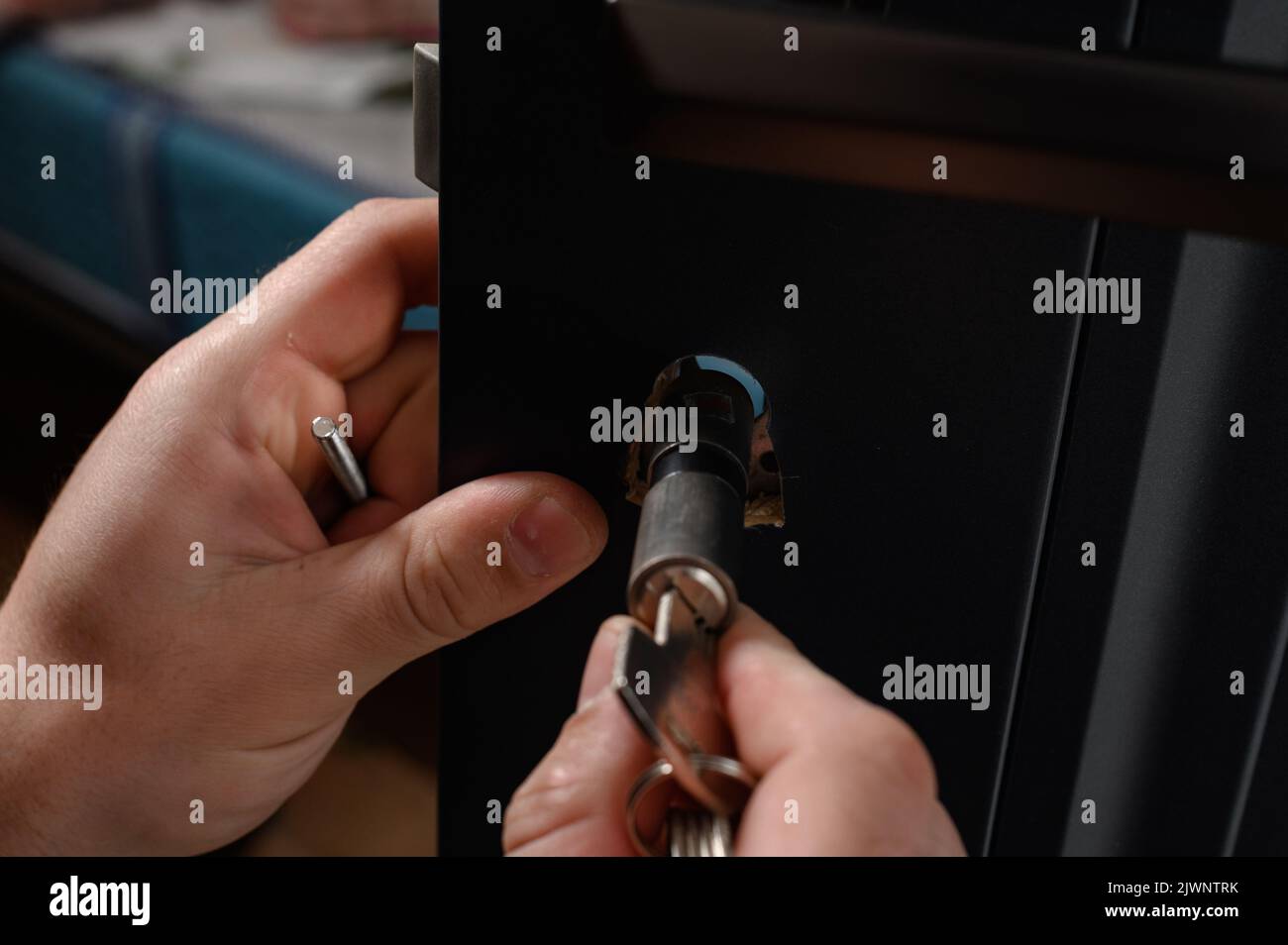 The master installs the core for the door lock, assembly work with the ...