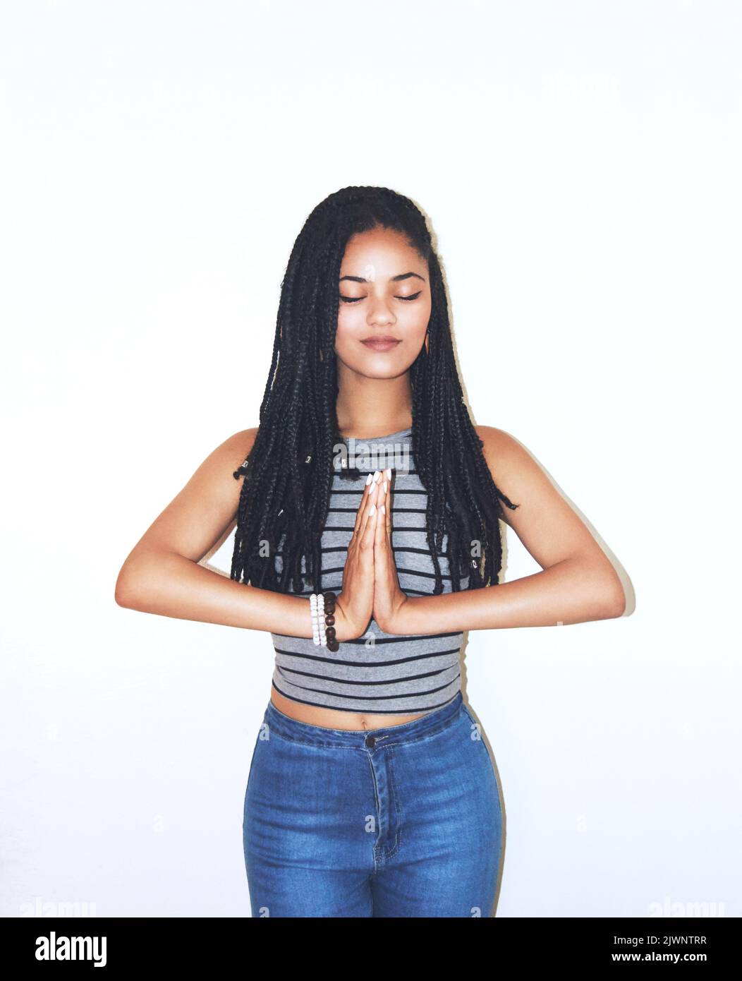 Finding her calm. Studio shot of an attractive young woman standing in ... Finding her calm. Studio shot of an attractive young woman standing in ...