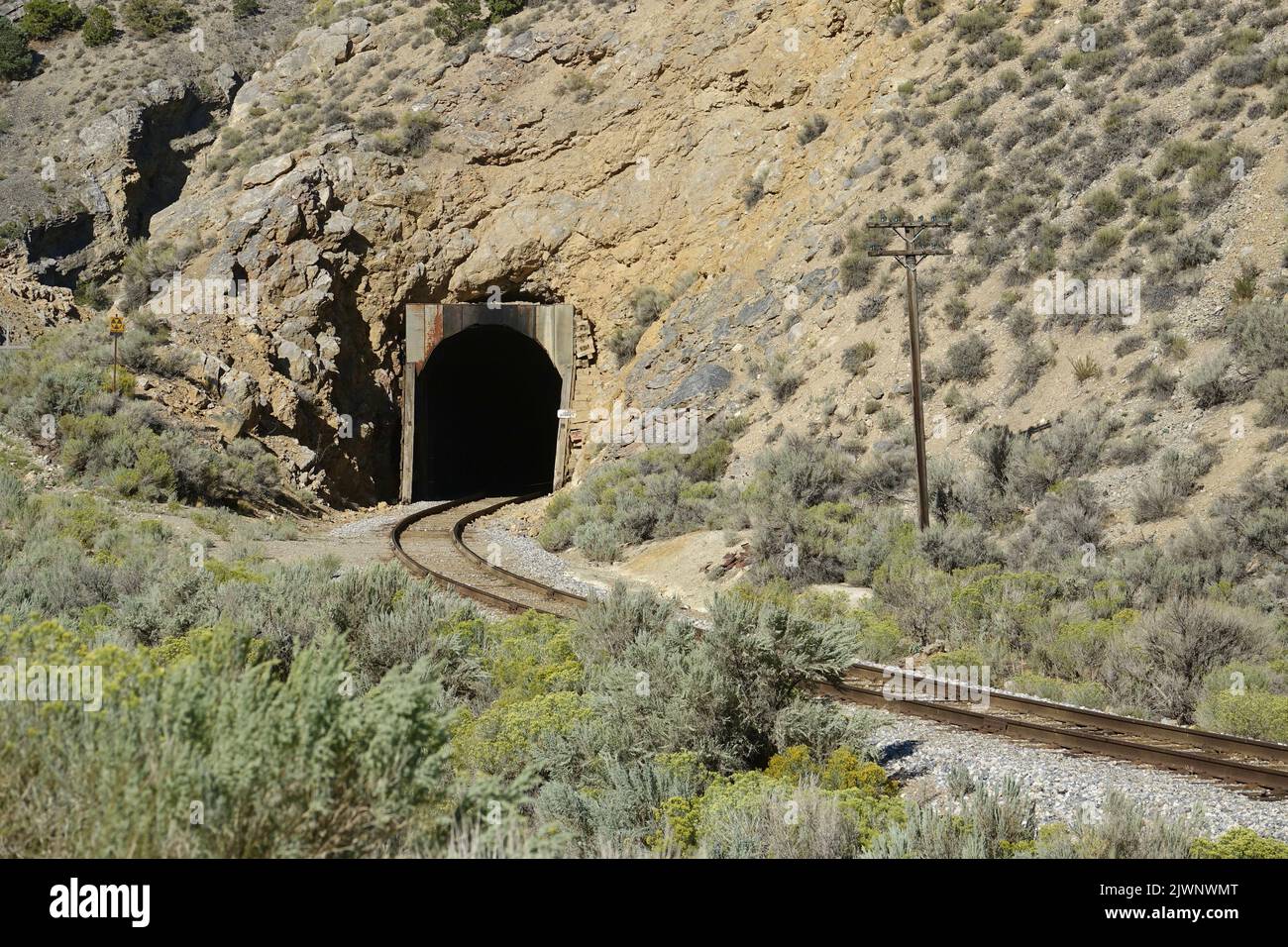 rustic train tunnel leading through the mountainside Stock Photo - Alamy