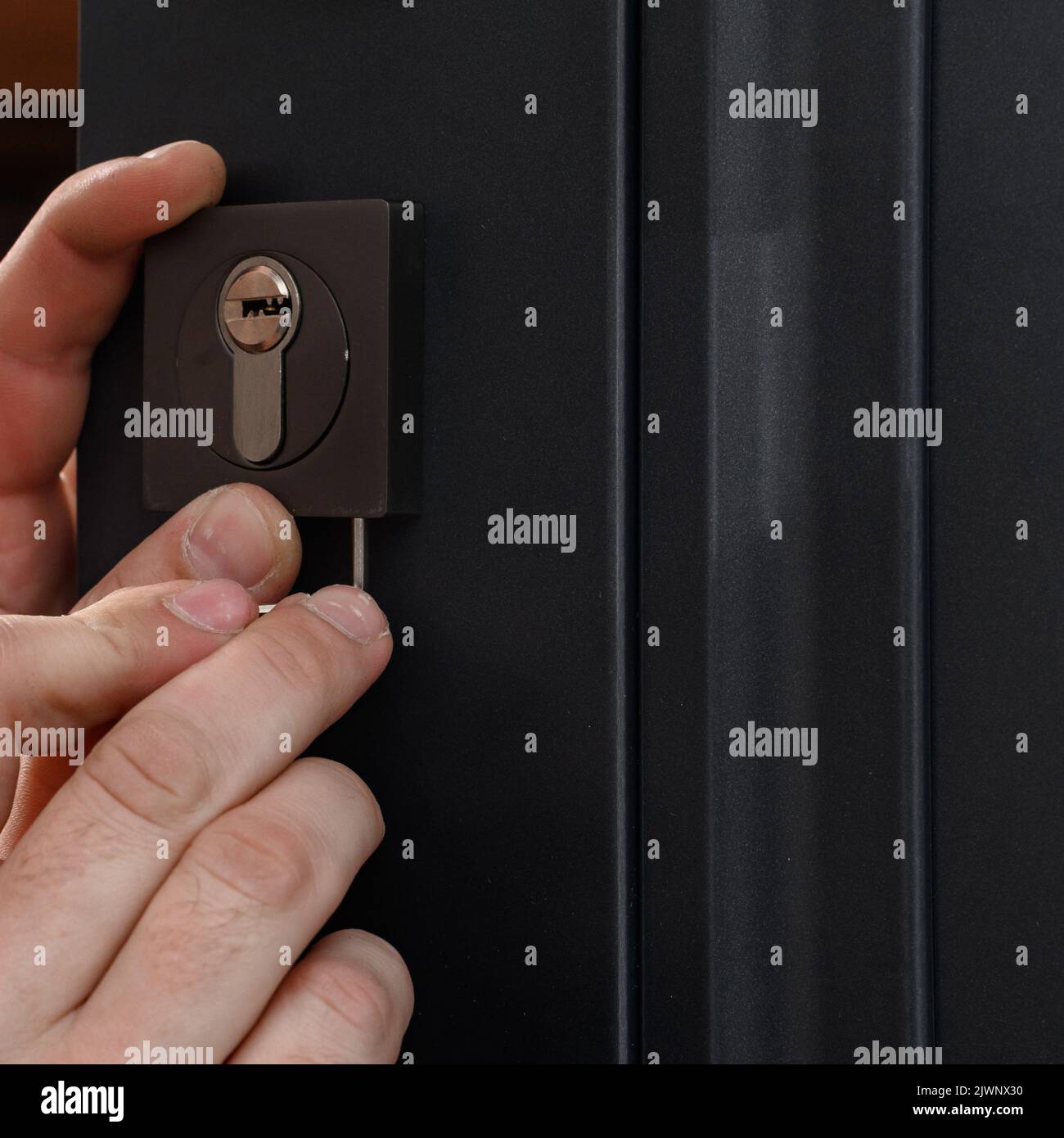 Installation of a door lock, a carpenter installs a door lock in a door ...