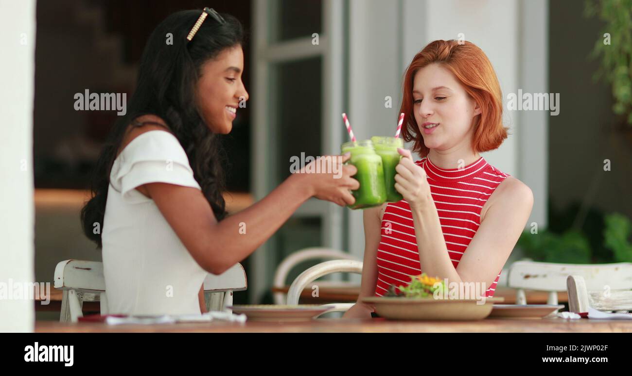 Multiracial friends toasting green juices. Multi-ethnic friendship ...