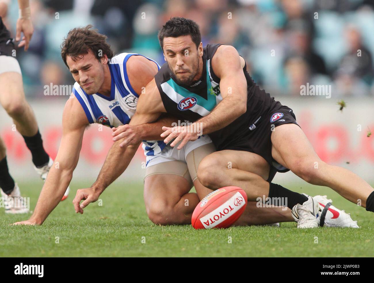 Cameron Pedersen of North Melbourne slides for the ball in front of ...