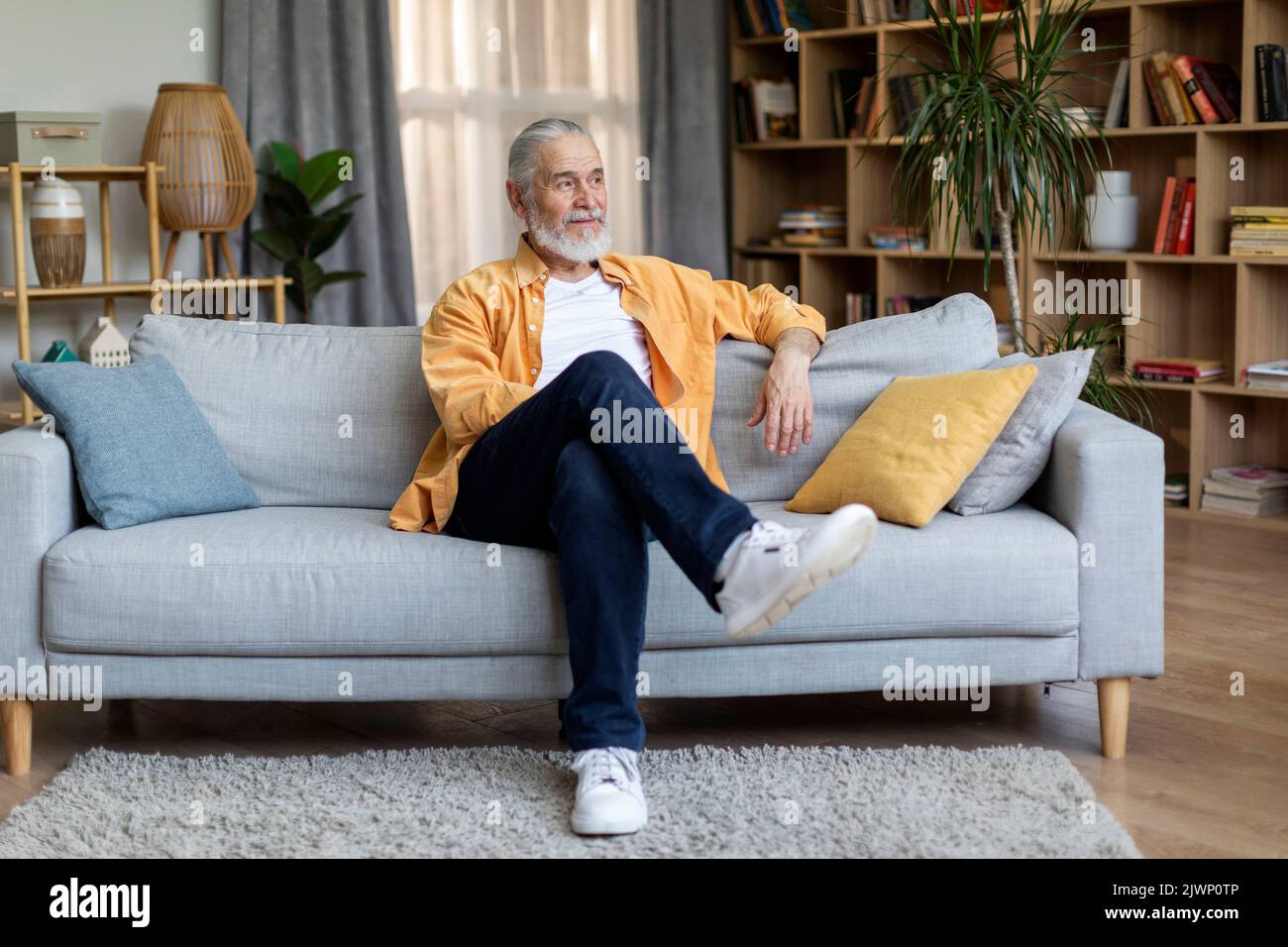Relaxed elderly man chilling on couch at home Stock Photo - Alamy