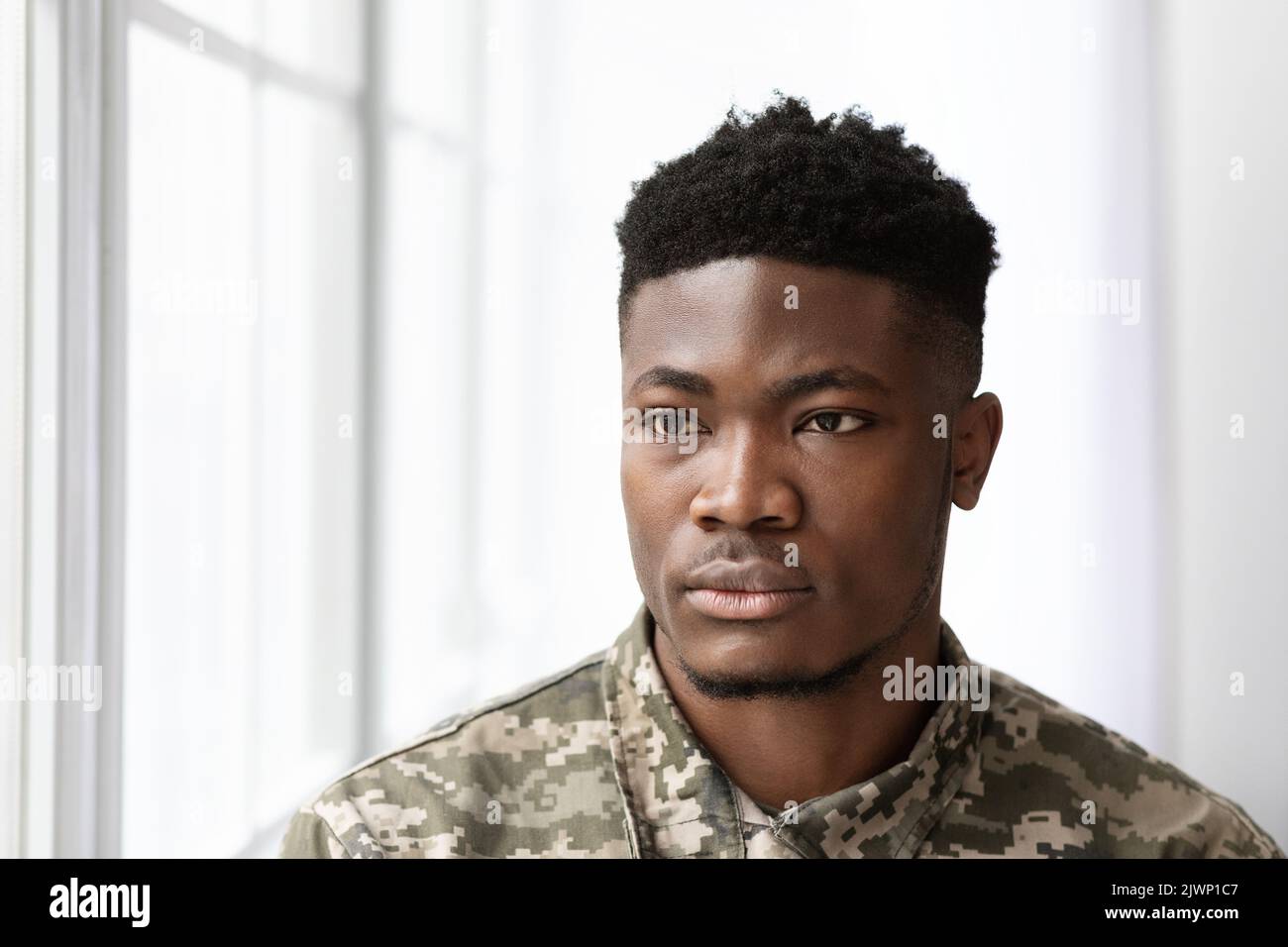 Serious african american man soldier looking through the window Stock ...