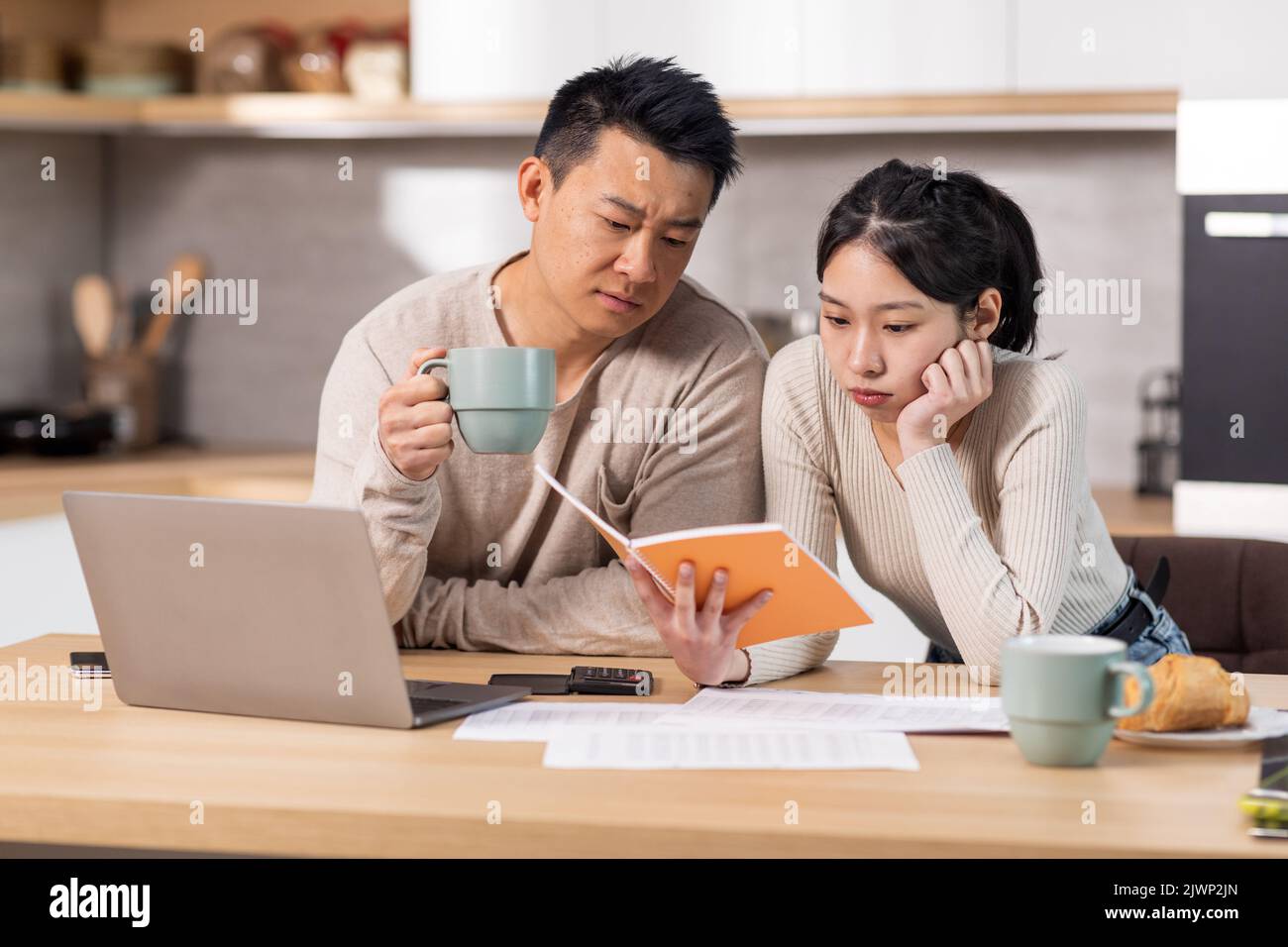 Asian family planning monthly budget together, kitchen interior Stock ...