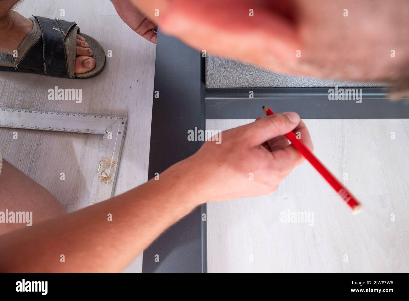 The craftsman measures the length of the plinth for cutting, installing ...