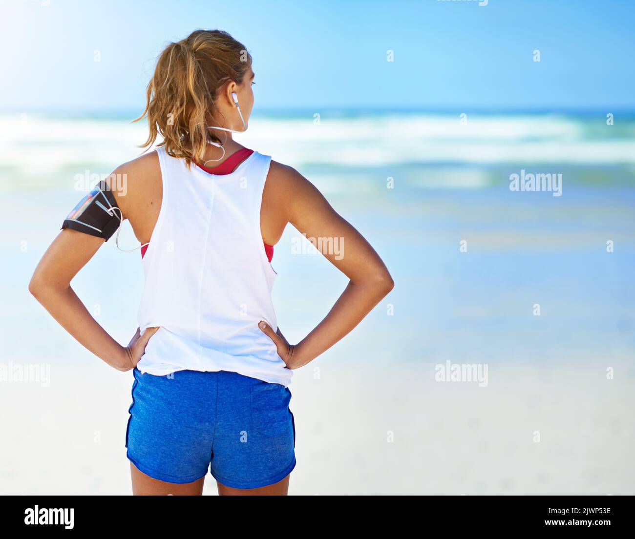 Exercise with a view. Rearview shot of a young woman standing with her ...