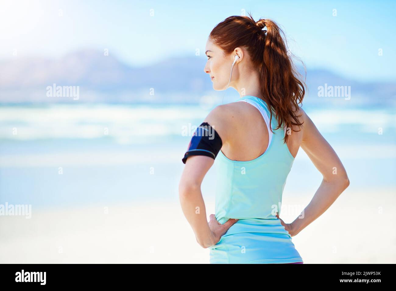 Taking it all in. a young woman standing with her hands on her hips on the beach Stock Photo - Alamy
