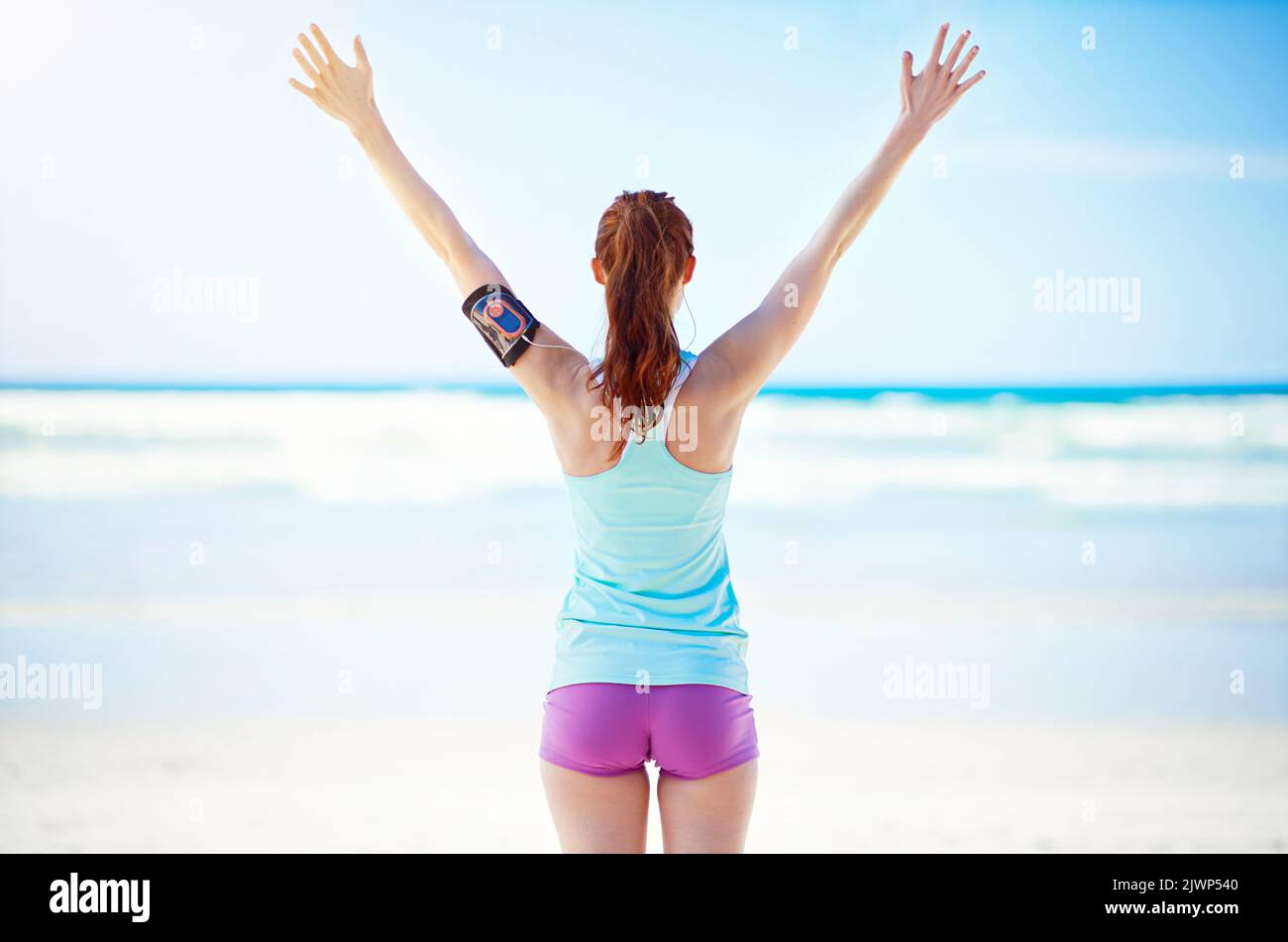 Feeling the freedom. Rearview shot of a young woman standing with her ...