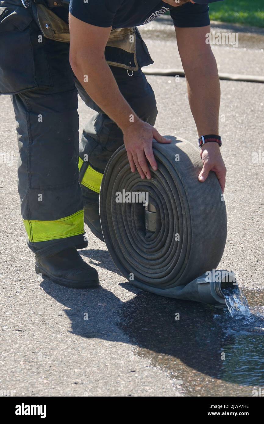 Rolling up fire hose hi-res stock photography and images - Alamy