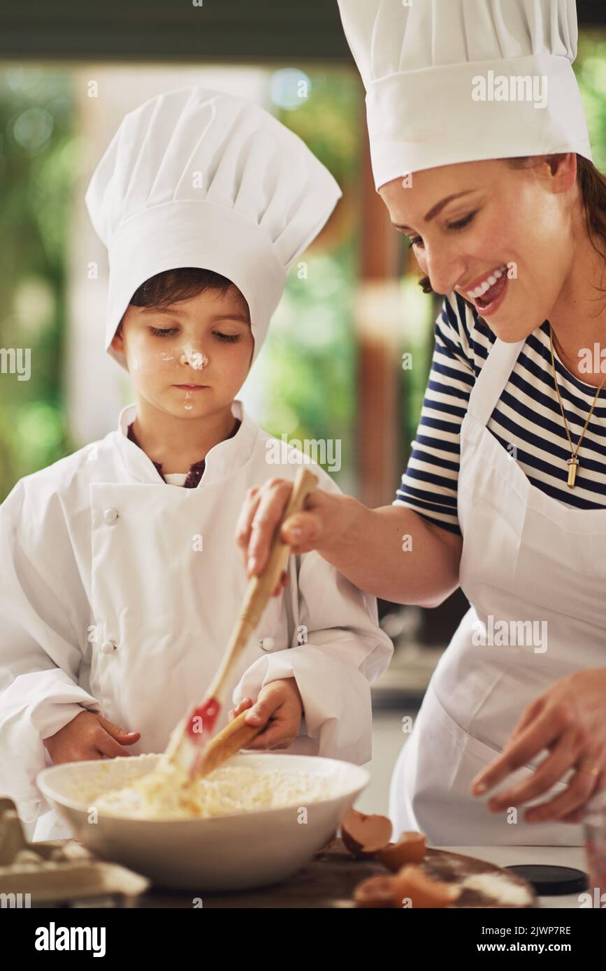Baking with love. a mother and her young son baking together in the ...