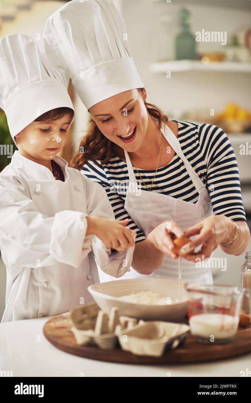 Passing on her love of baking. a mother and her young son baking ...