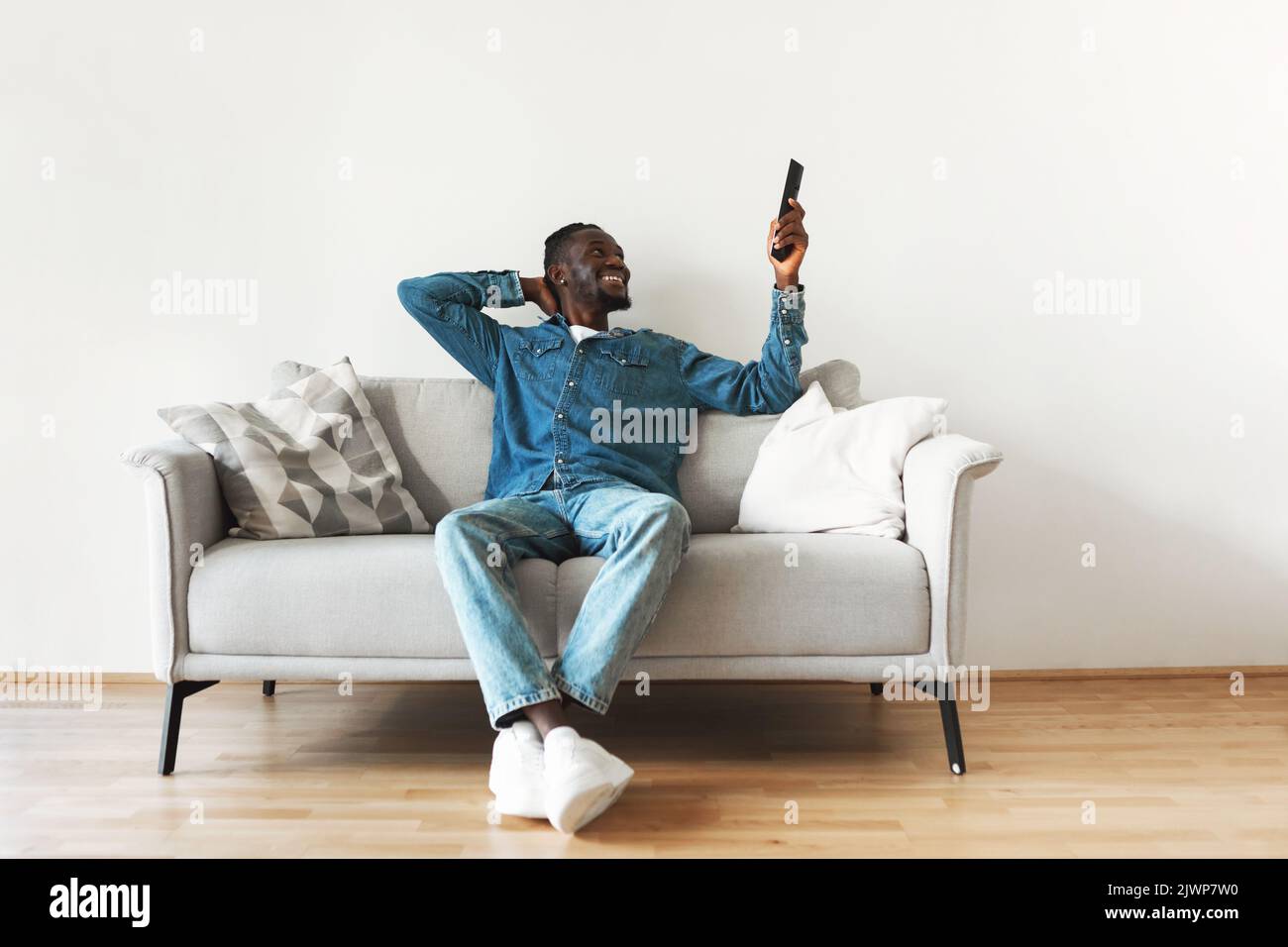 African American Man Turning On AC Air Conditioning At Home Stock Photo ...
