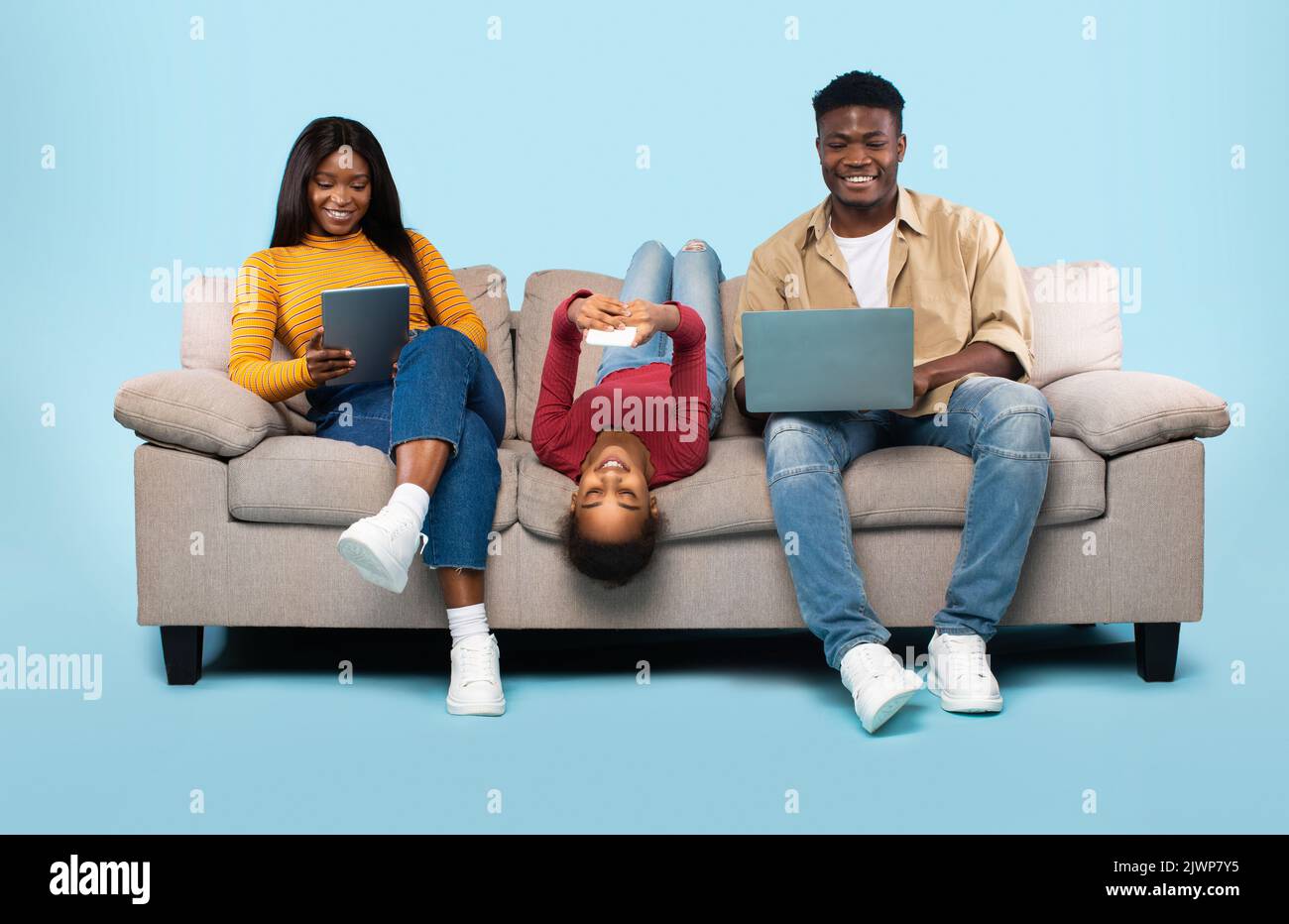 Gadgets addiction concept. African american family of three using ... Gadgets addiction concept. African american family of three using ...
