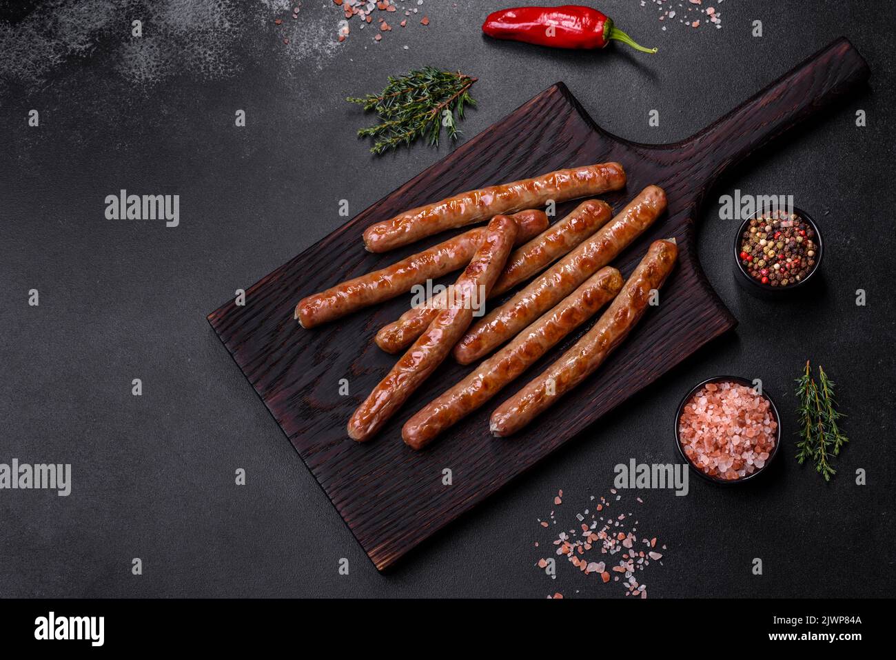 Grilled sausage with the addition of herbs and vegetables on the wooden ...