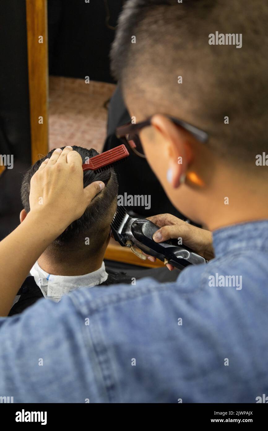 barber using a shaver performing a shave haircut, work in a barbershop ...