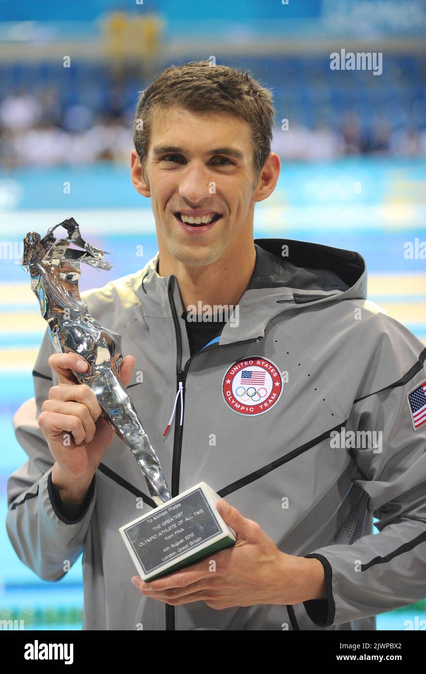 Michael Phelps poses for a photo after being presented with a trophy ...