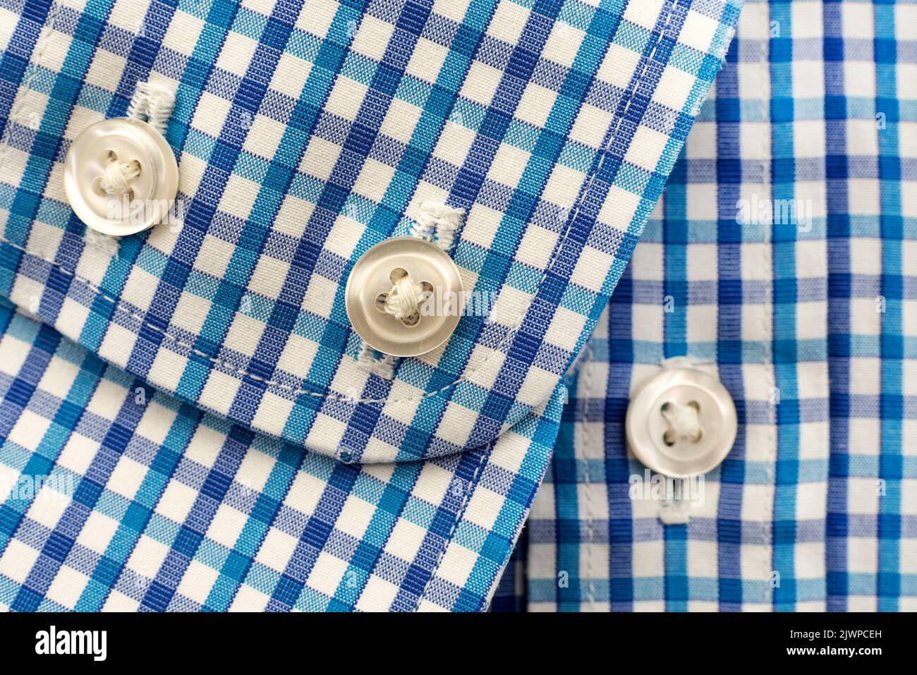 Buttons on the sleeve of the shirt in blue checkered material. Button ...